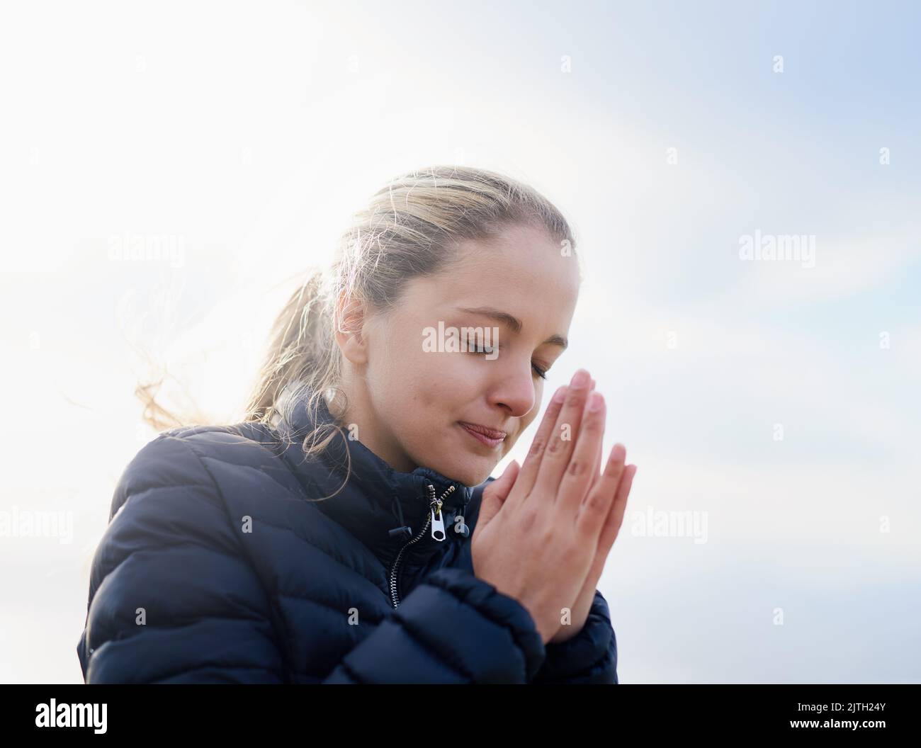 Finding strength and peace through prayer. an attractive young woman ...