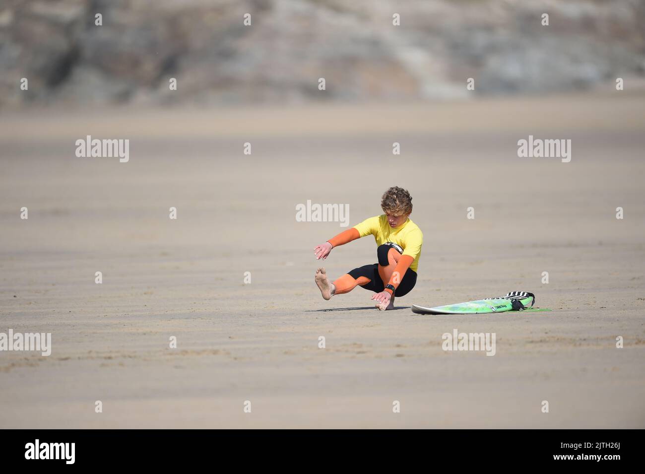 Surfer doing warm up exercises on beach before event Stock Photo - Alamy