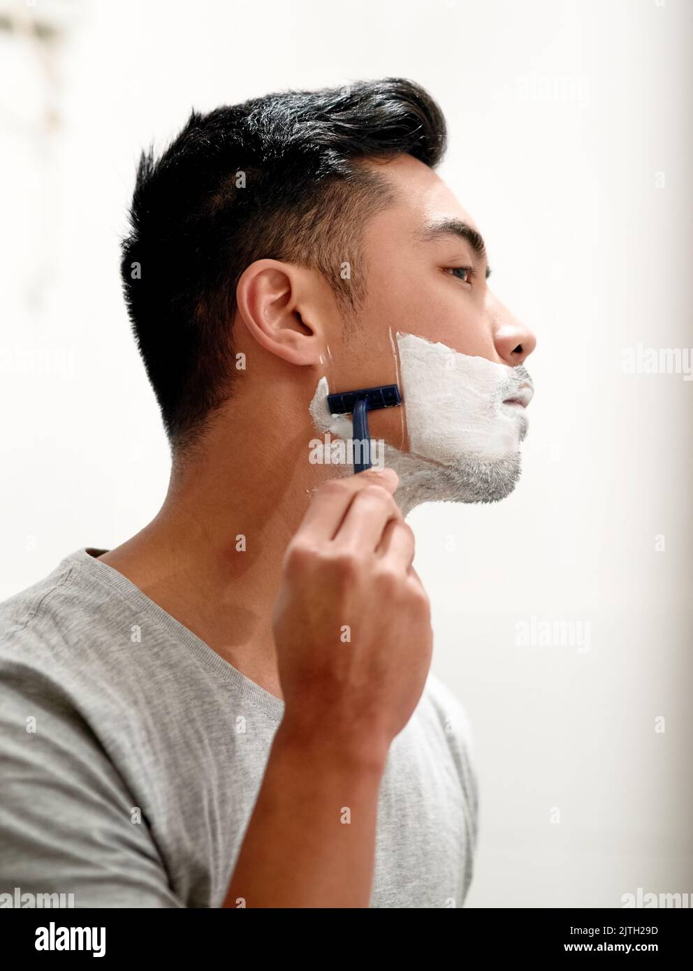 Ill face the day with a smooth face. a serious young man shaving his ...