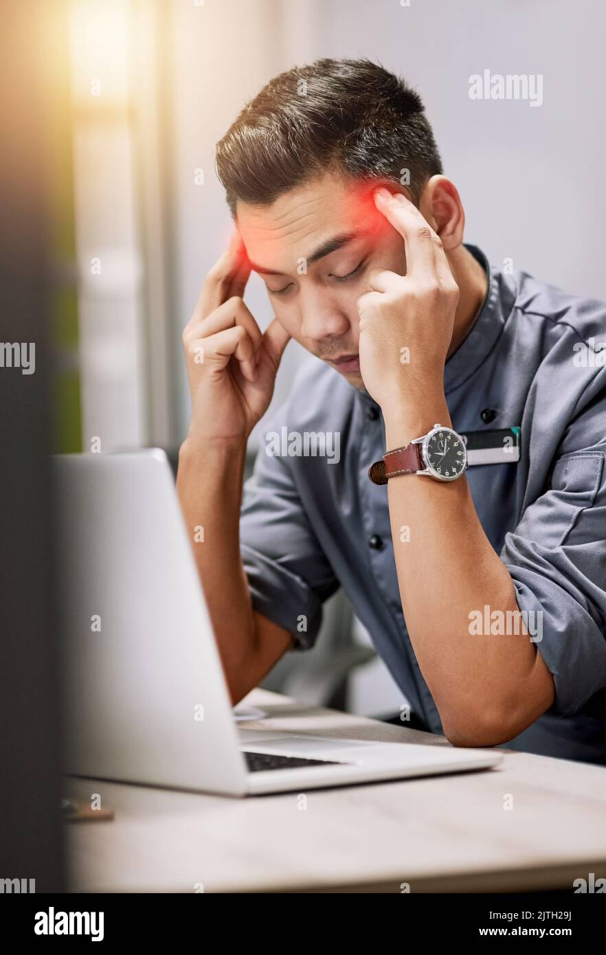 The stress is giving him a headache. a young man suffering with a ...
