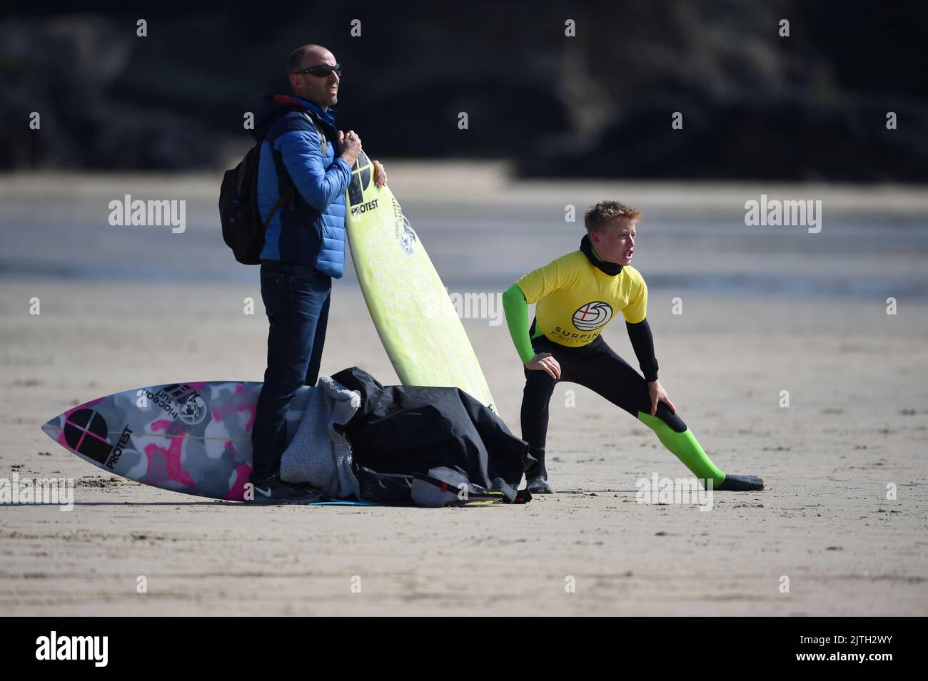 Surfer doing warm up exercises on beach before event Stock Photo - Alamy