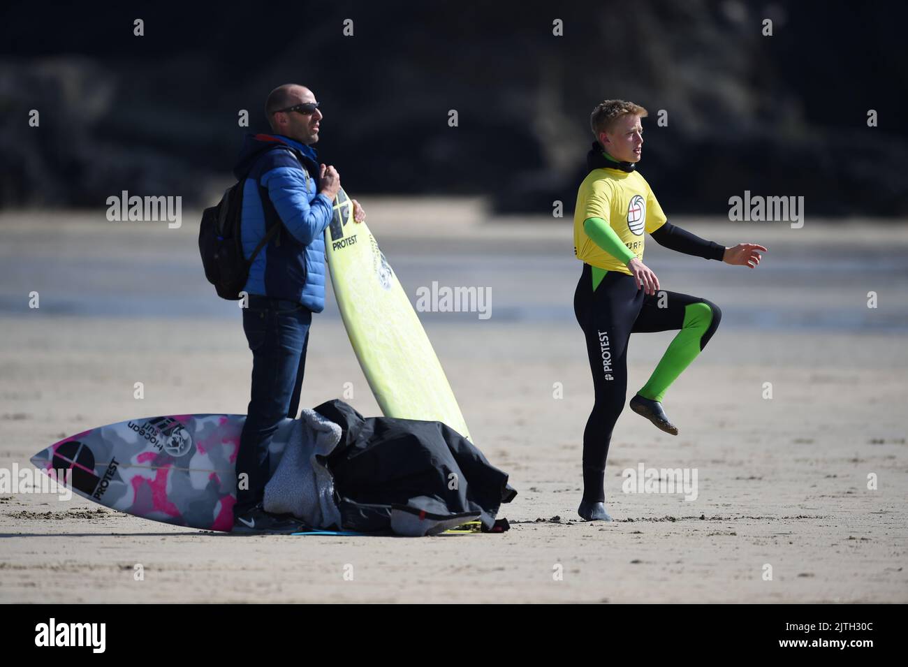 Surfer doing warm up exercises on beach before event Stock Photo - Alamy
