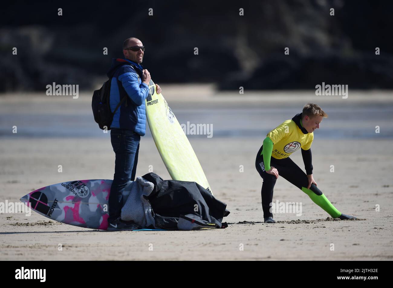 Surfer doing warm up exercises on beach before event Stock Photo - Alamy