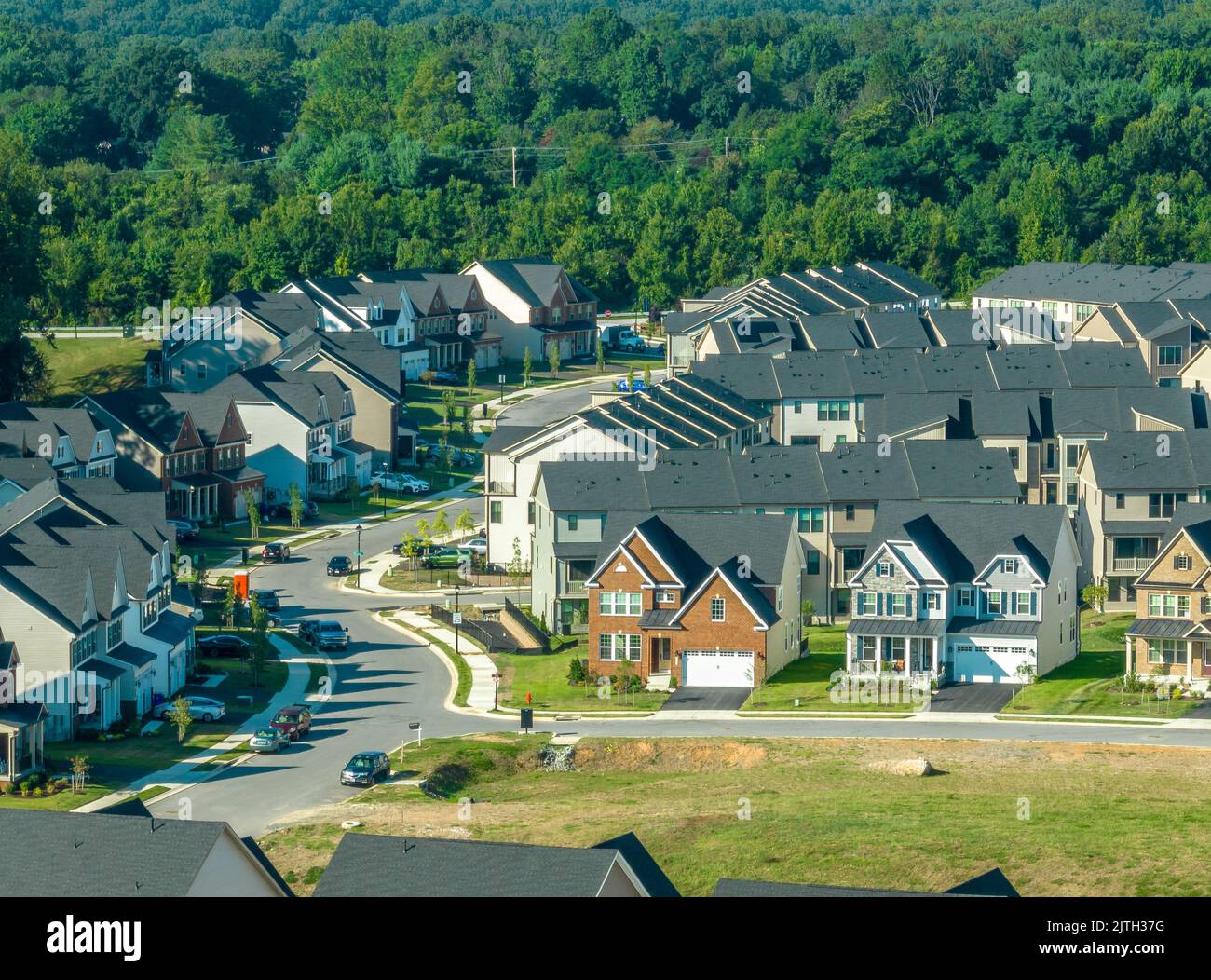 Modern single family homes line a curving street in a new neighborhood ...
