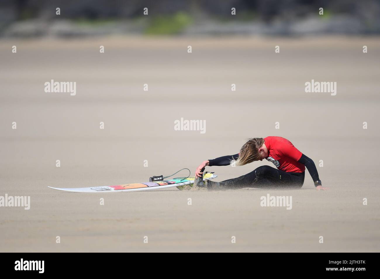 Surfer doing warm up exercises on the beach Stock Photo - Alamy