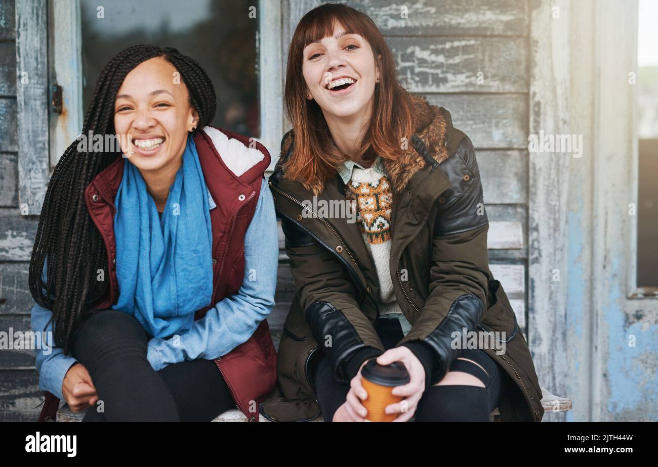 Life is better when were laughing. Portrait of two friends sitting on ...