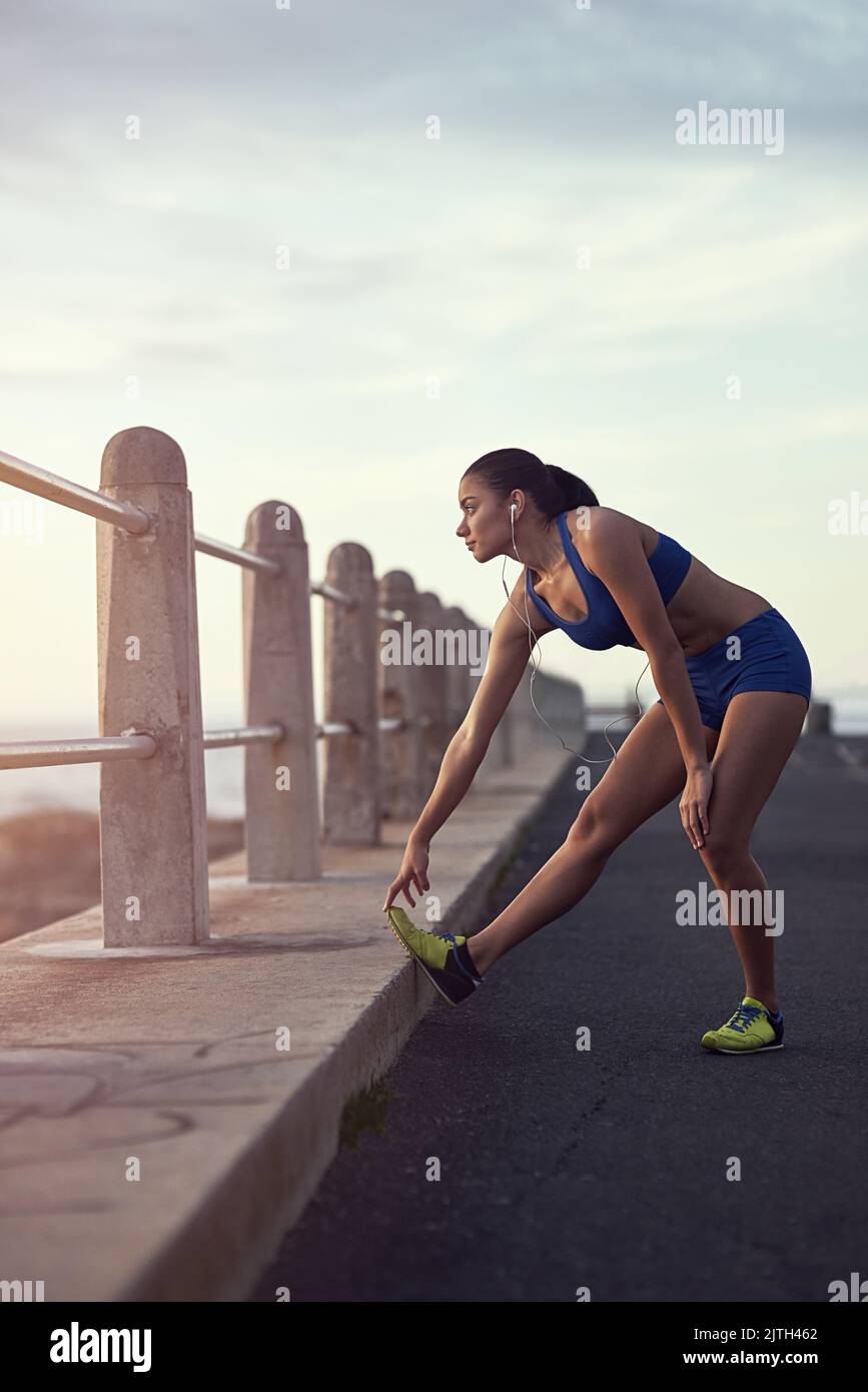 Working out anywhere anytime. a fit young woman warming up during her ...