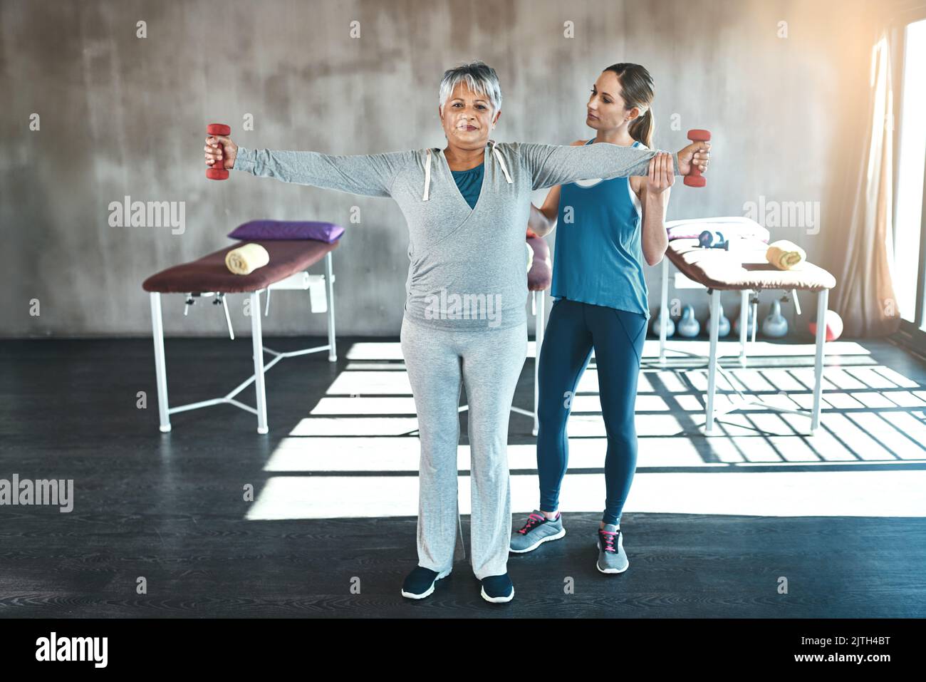 Staying strong in the senior years. a senior woman using weights with ...