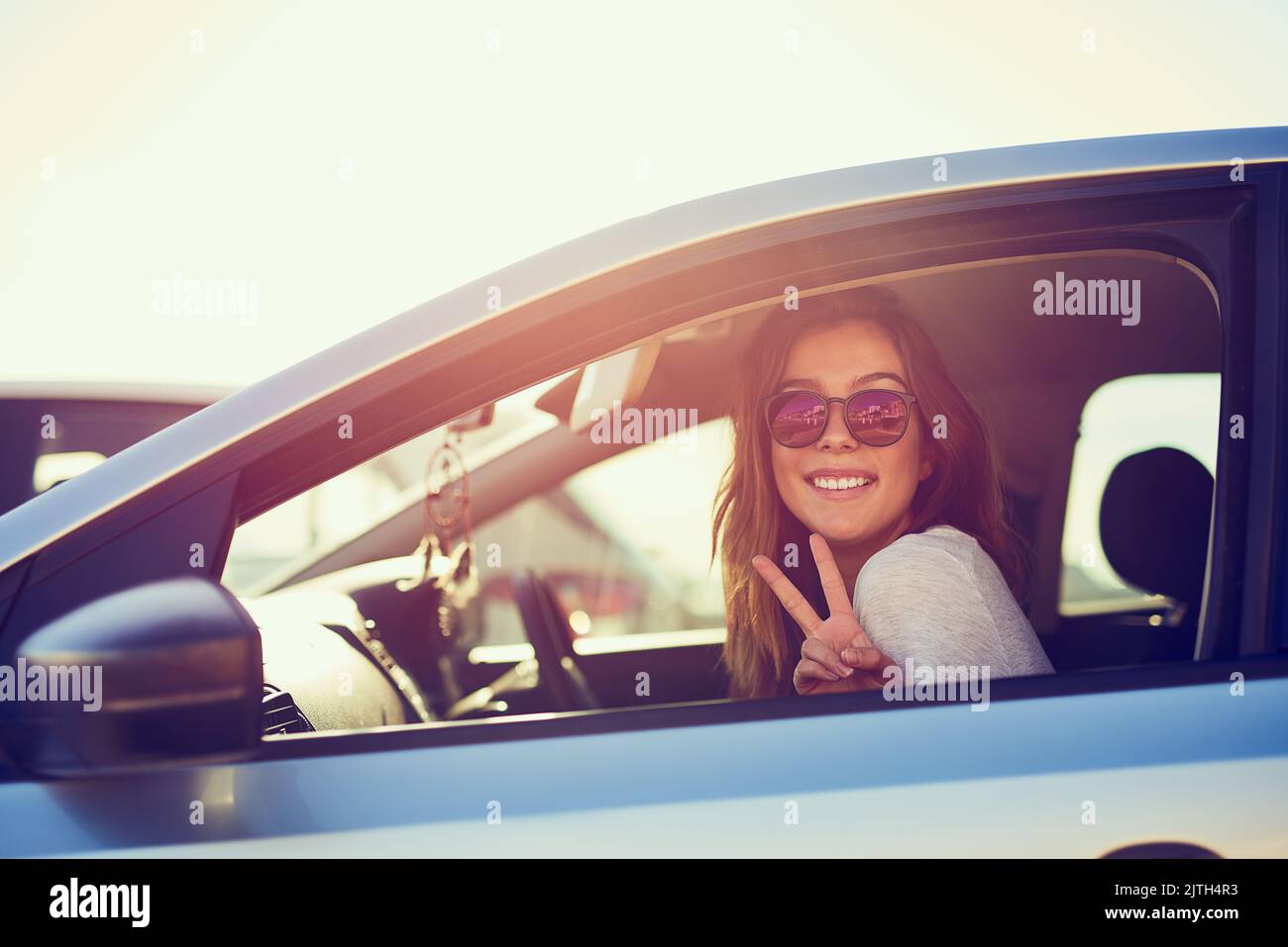 Peace. Portrait of a young woman giving you the peace sign while ...