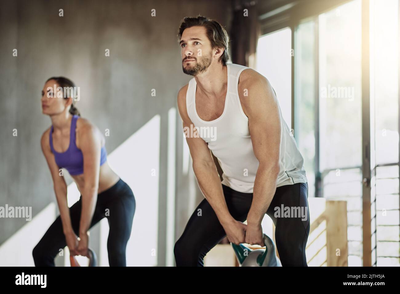 Its a question of strength. two young people working out in the gym ...