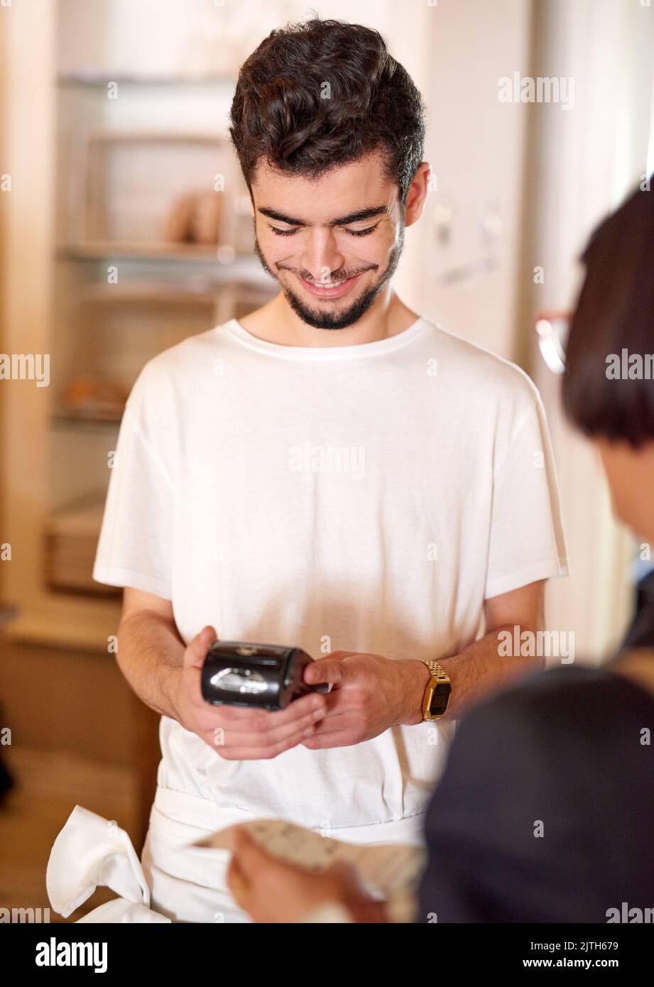 Payments made easy. a young shop assistant helping a customer with a payment terminal in a shop ...