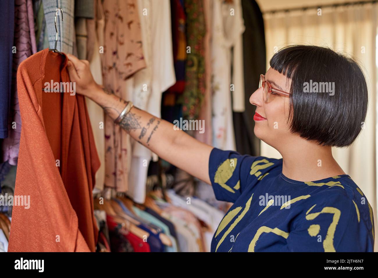 She loves her fashion. a stylish young woman browsing clothing on a ...