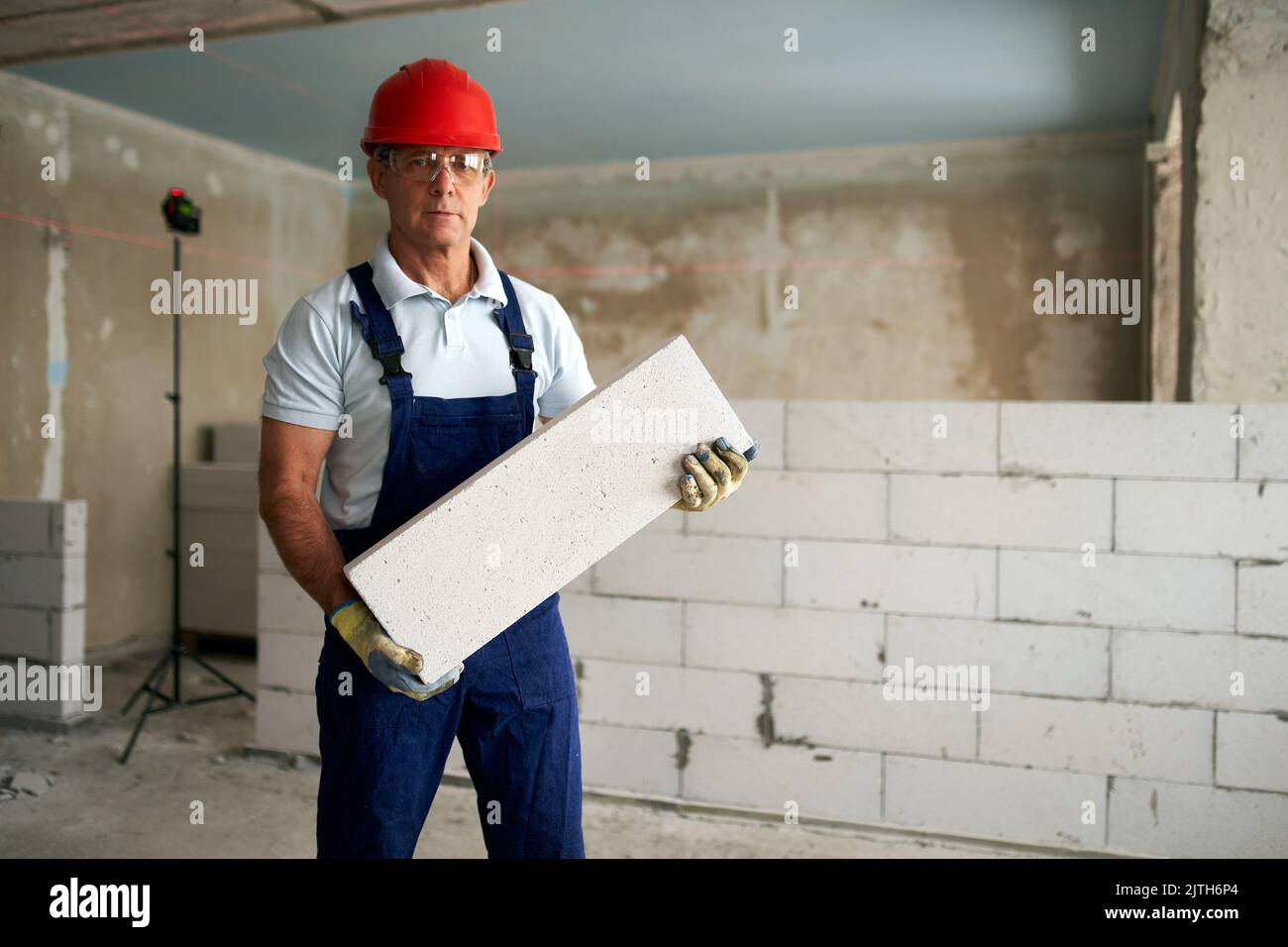Bricklayer or mason constructs wall of autoclaved aerated concrete ...