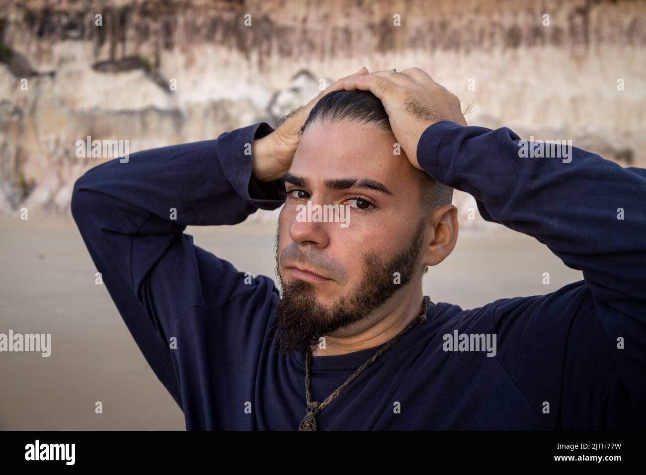 white man in his 30s holding his head with both hands with a wistful ...