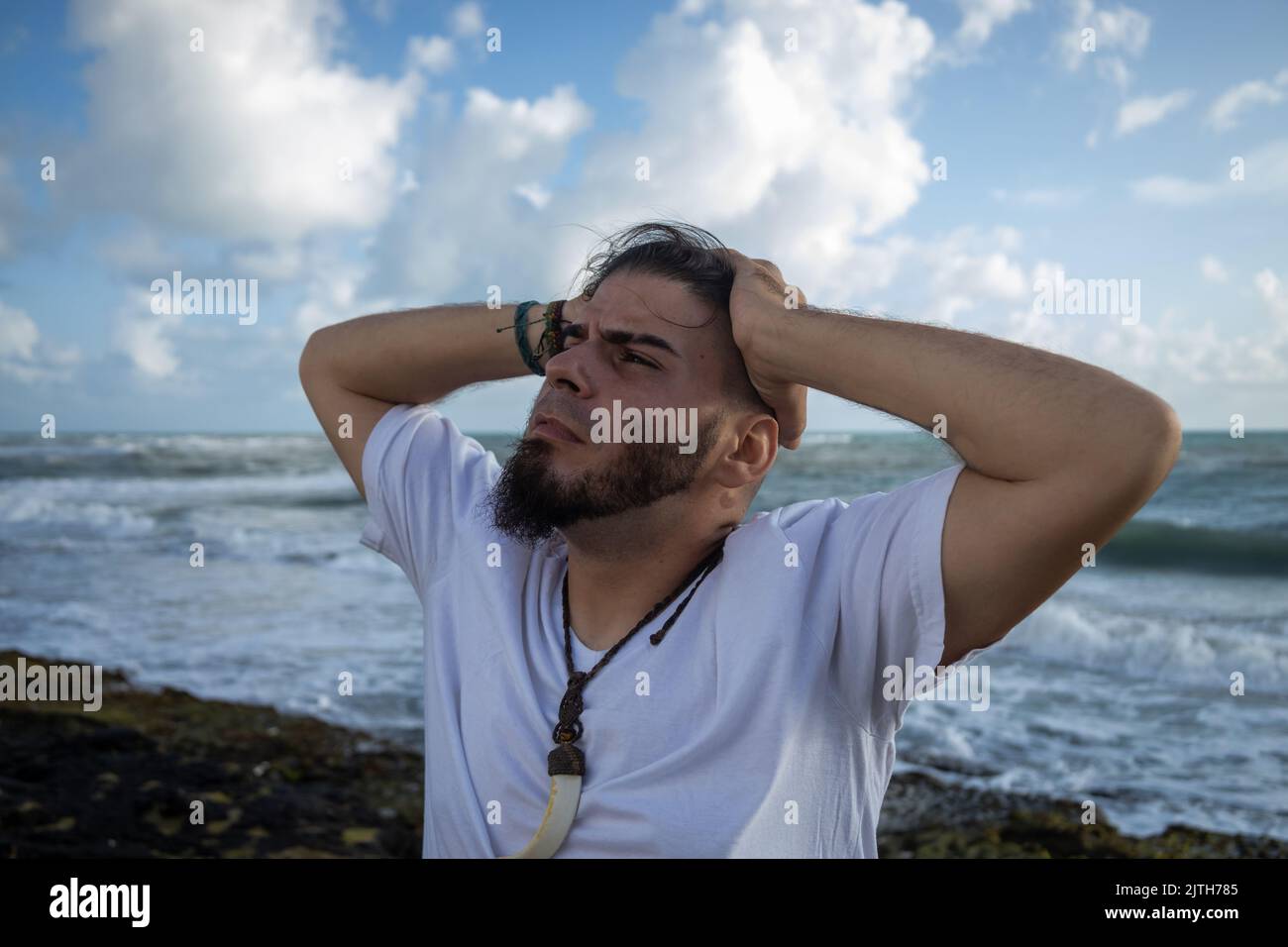 white man in his 30s holding his head with both hands with a wistful ...