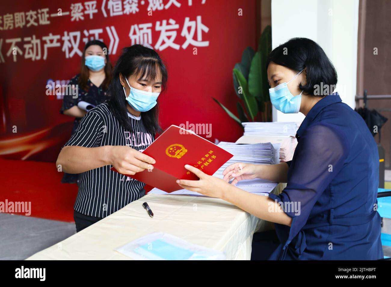 CHONGQING, CHINA - AUGUST 30, 2022 - A homebuyer (L) receives a ...