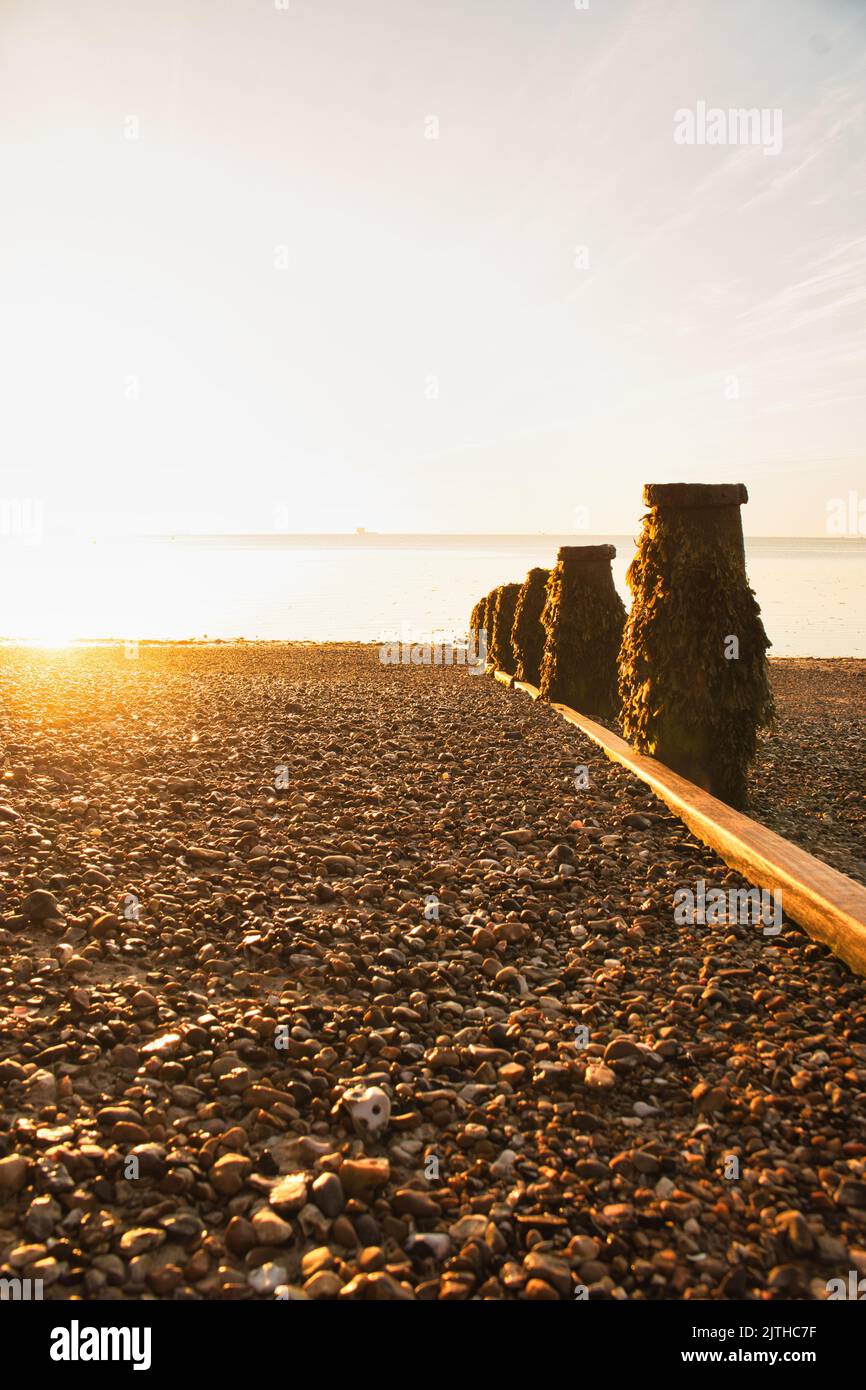 The iron pillars on the beach at sunset, vertical Stock Photo - Alamy