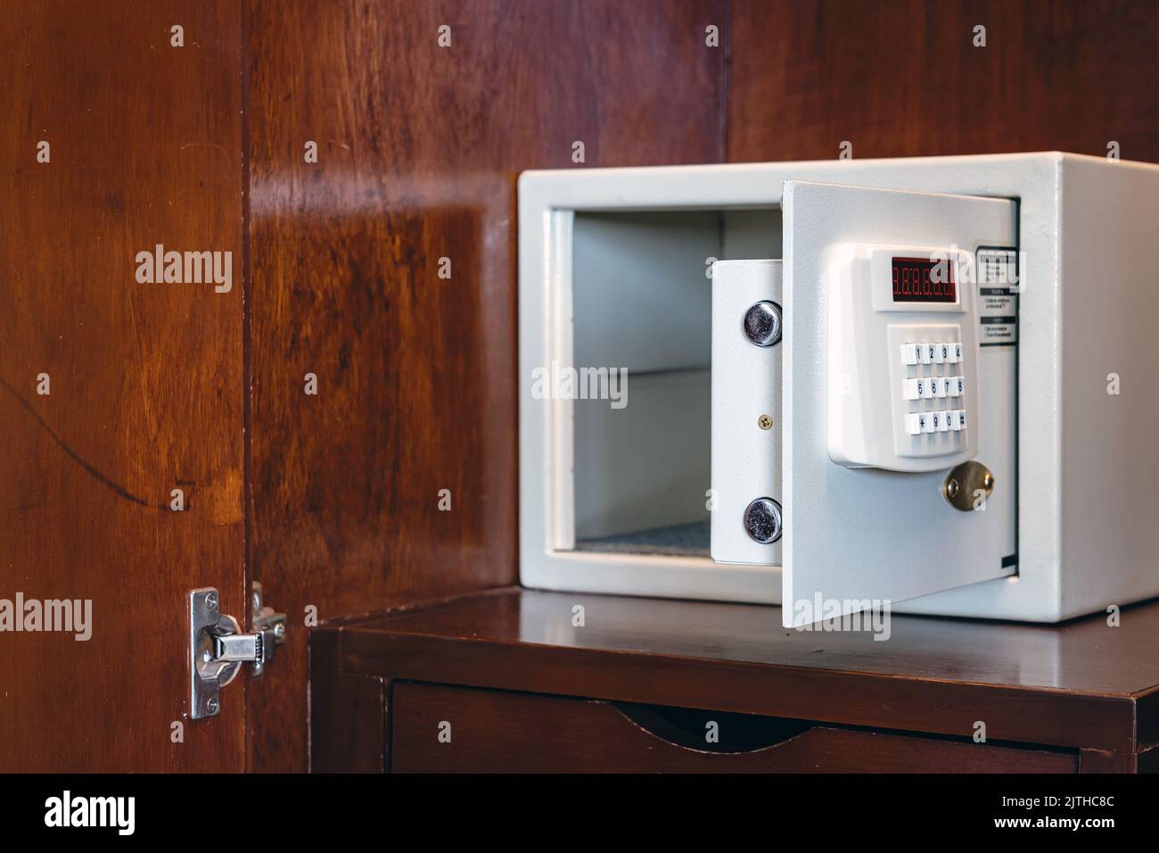 Security open metal safe with empty space inside in a wooden shelf ...