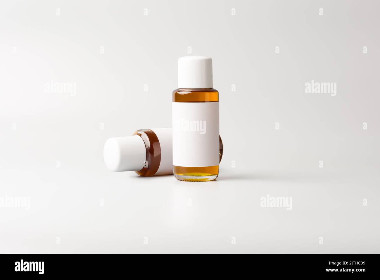 small oil bottles with white caps, with blank labels, mock-up template ...