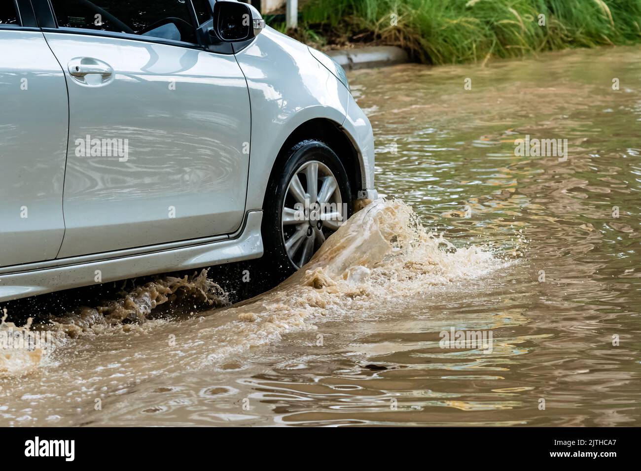 Car passing through a flooded road. Driving car on flooded road during ...