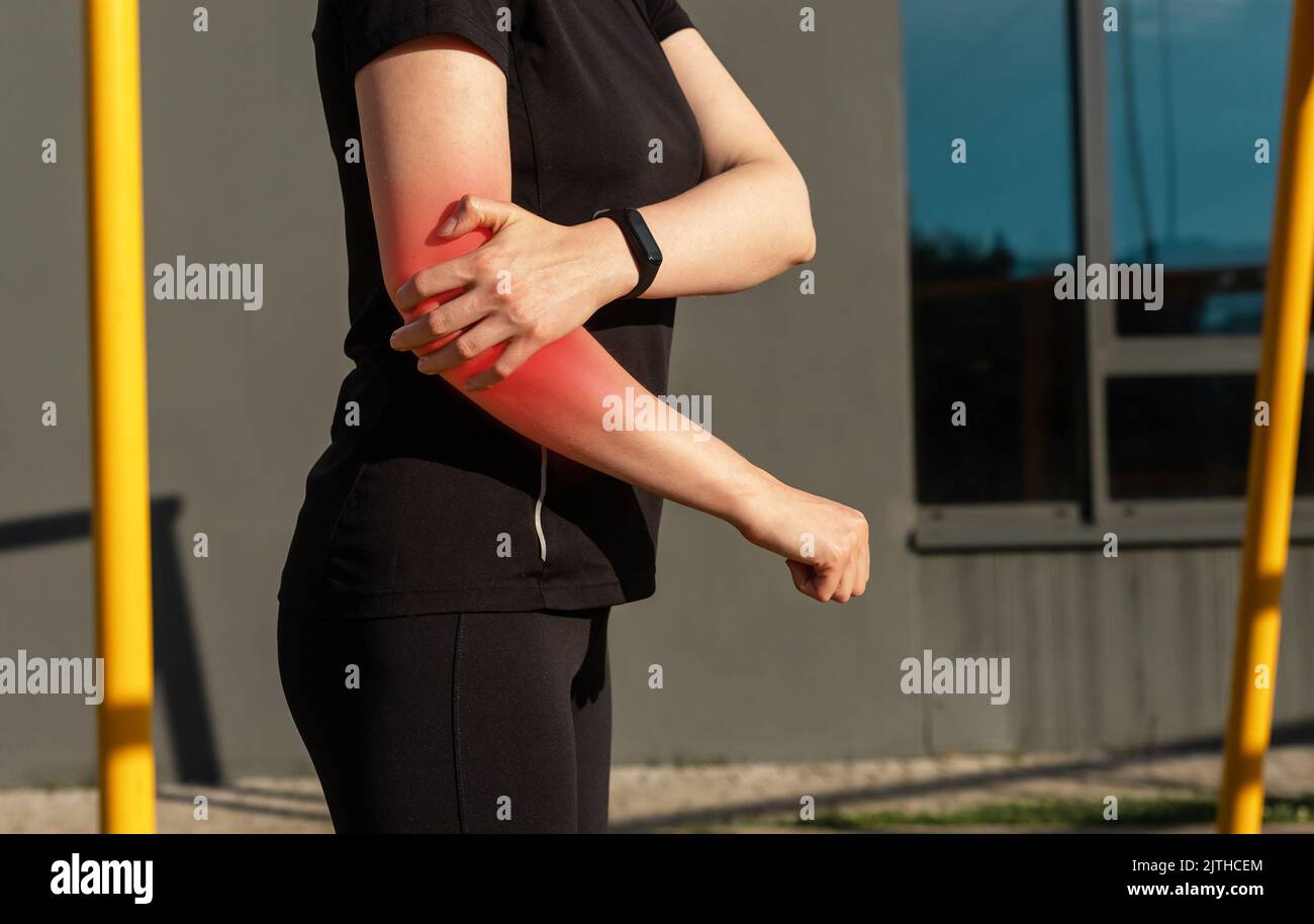 Woman doing sport and suffering from elbow pain. Female holding painful ...