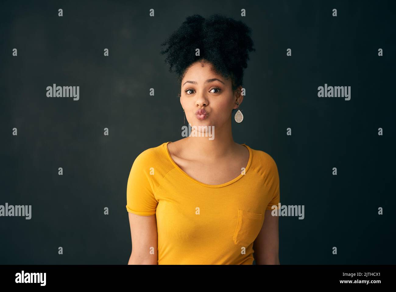 This is my cute face. a young woman posing against a grey background ...