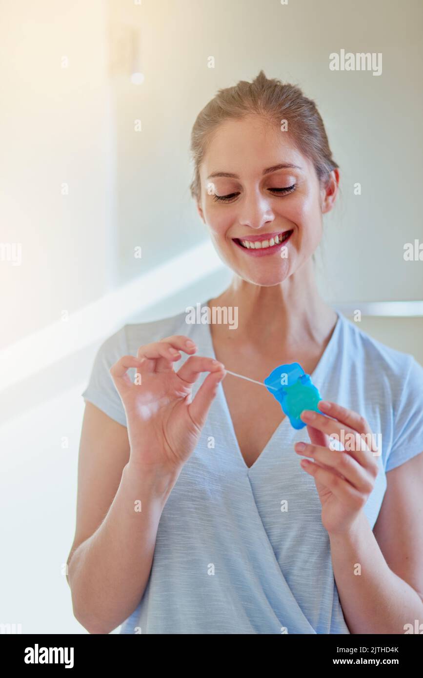 Polishing Up Her Winning Smile A Young Woman Flossing Her Teeth In A