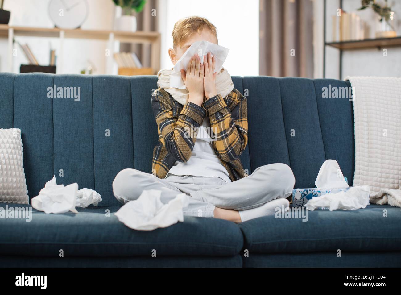 Sick exhausted teenager boy with scarf around neck, blowing running ...