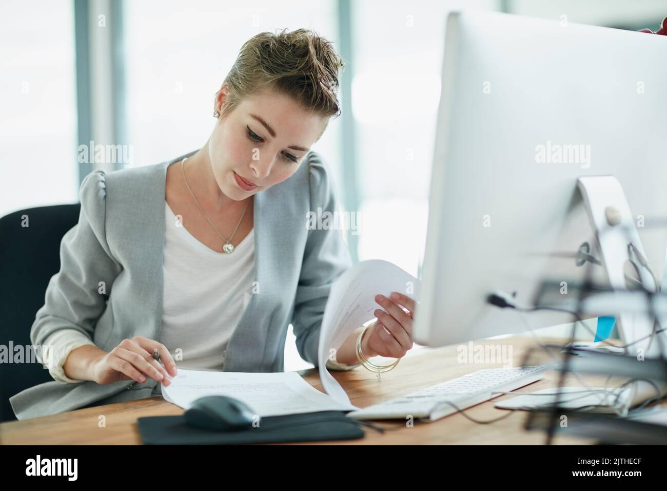 Fact-checking all the details. a young businesswoman reading some ...