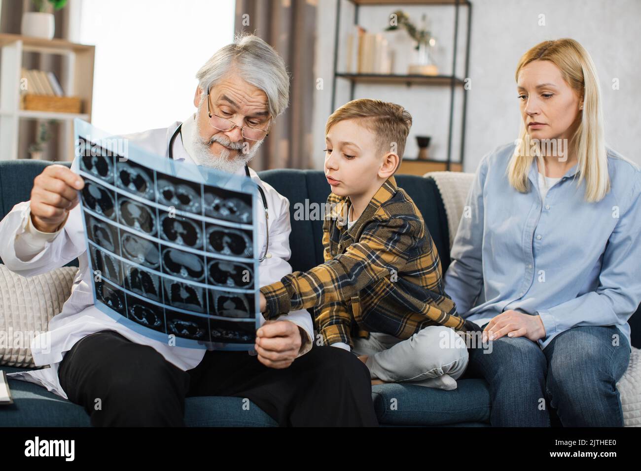 Pleasant mature man doctor supporting his preschool male patient with ...