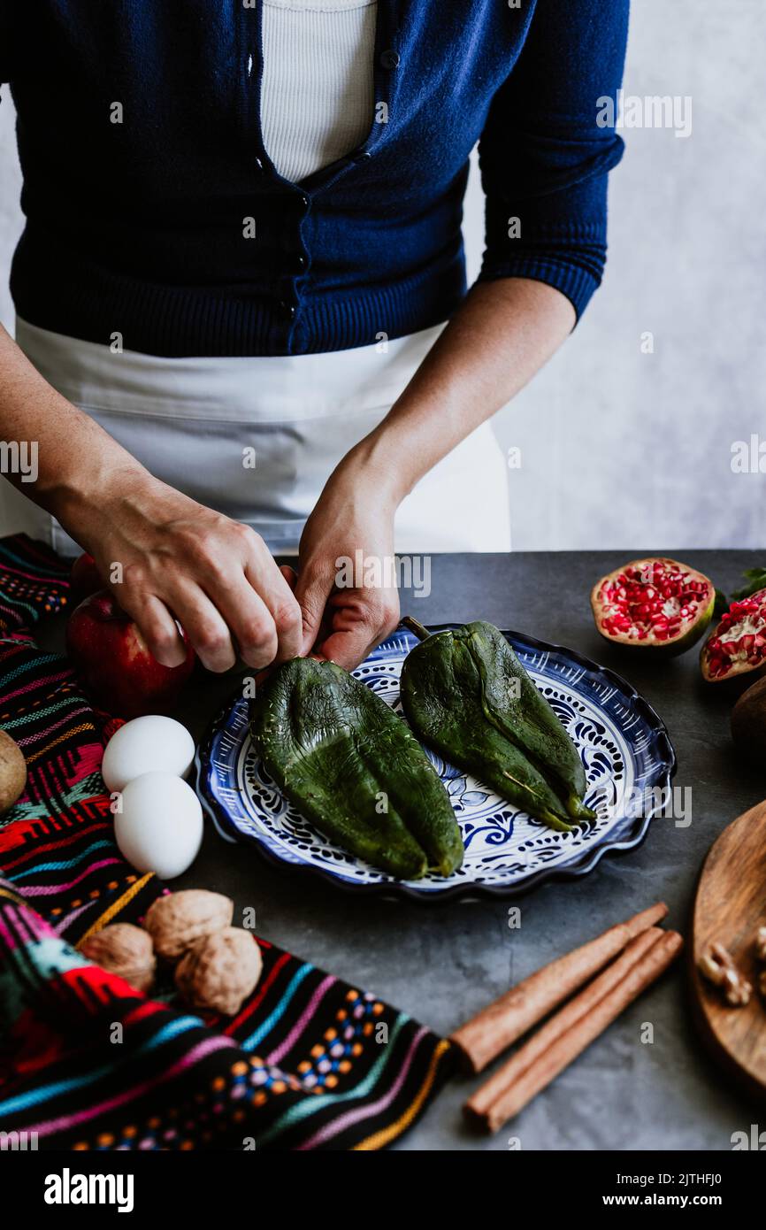 mexican woman hands peeling poblano chillies pepper for cooking chiles ...