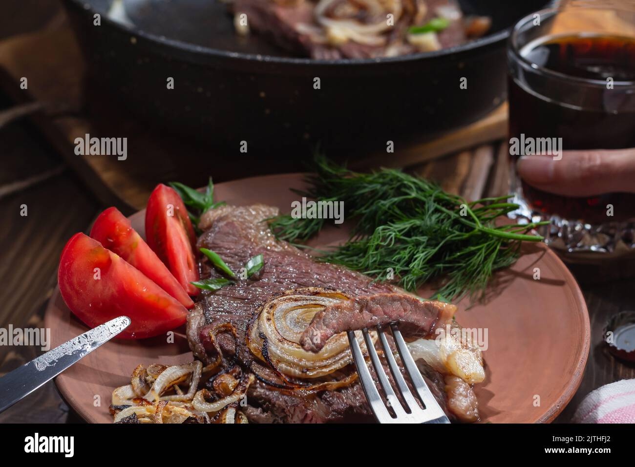 female hand holds glass with dark beer.piece of grilled marbled beef ...