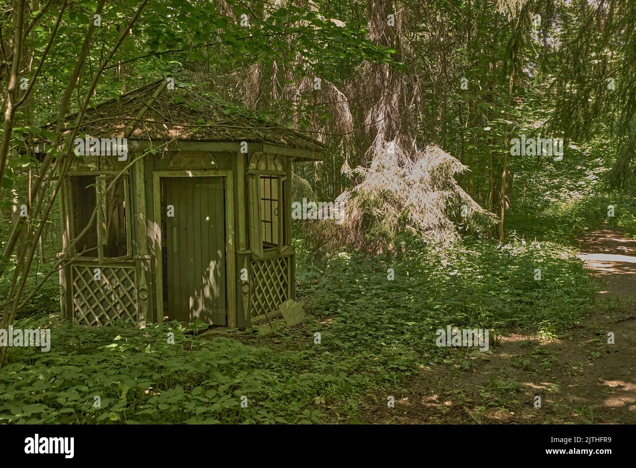 Summer cloudy day. There is an old dilapidated summer gazebo in the ...