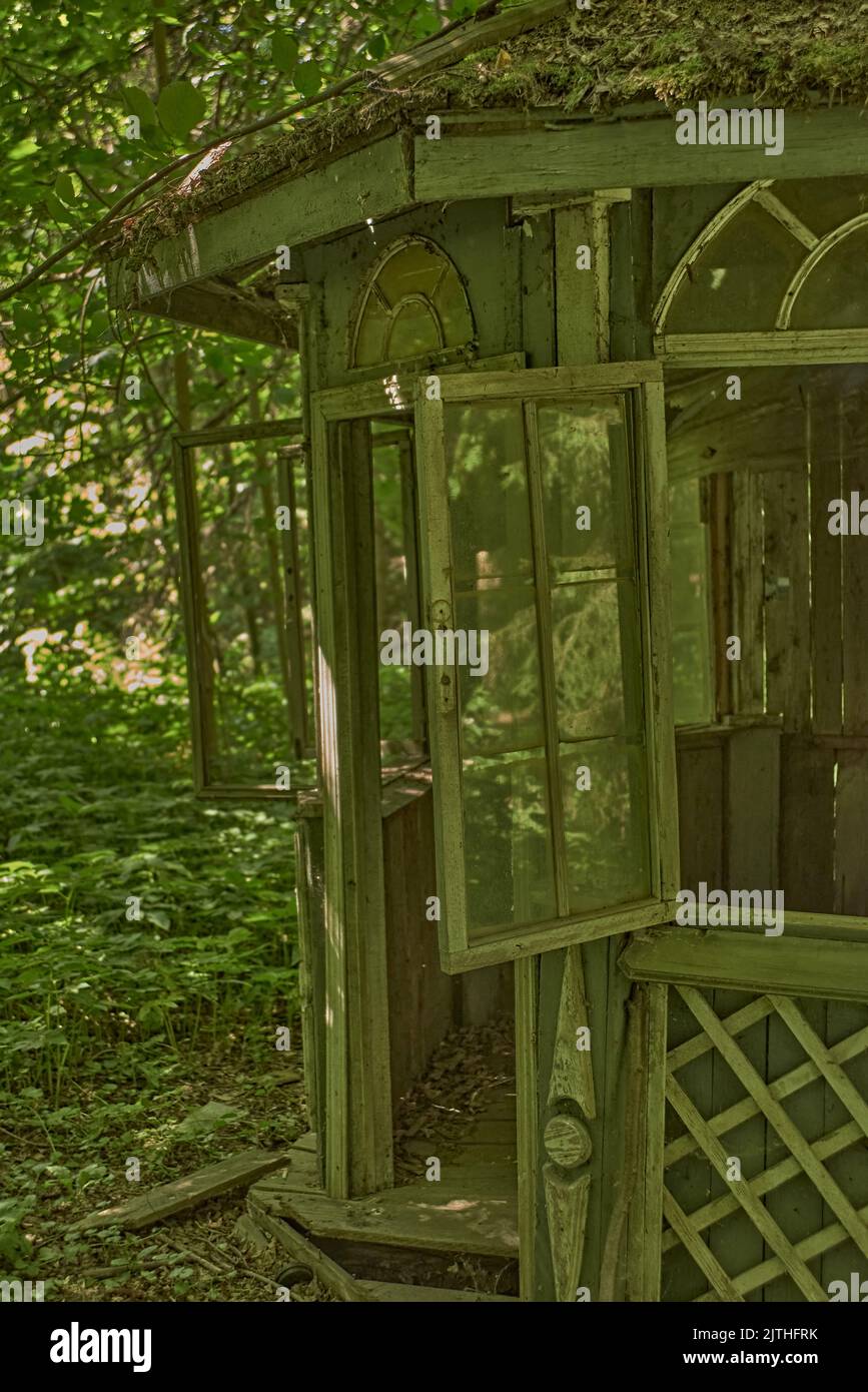 Summer cloudy day. There is an old dilapidated summer gazebo in the ...