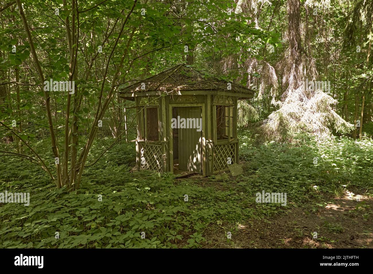 Summer cloudy day. There is an old dilapidated summer gazebo in the ...