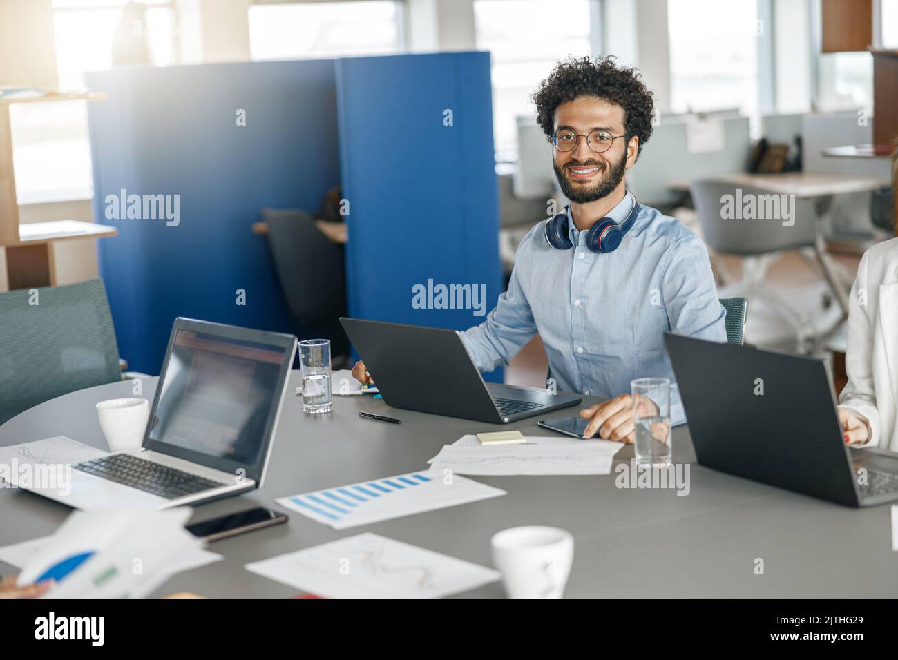 Businessman working laptop while sitting in modern office on colleagues ...