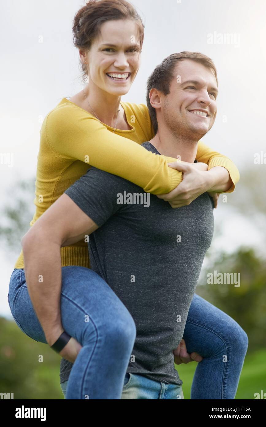 Laid-back summer romance. a happy man giving his wife a piggyback ride outside Stock Photo - Alamy