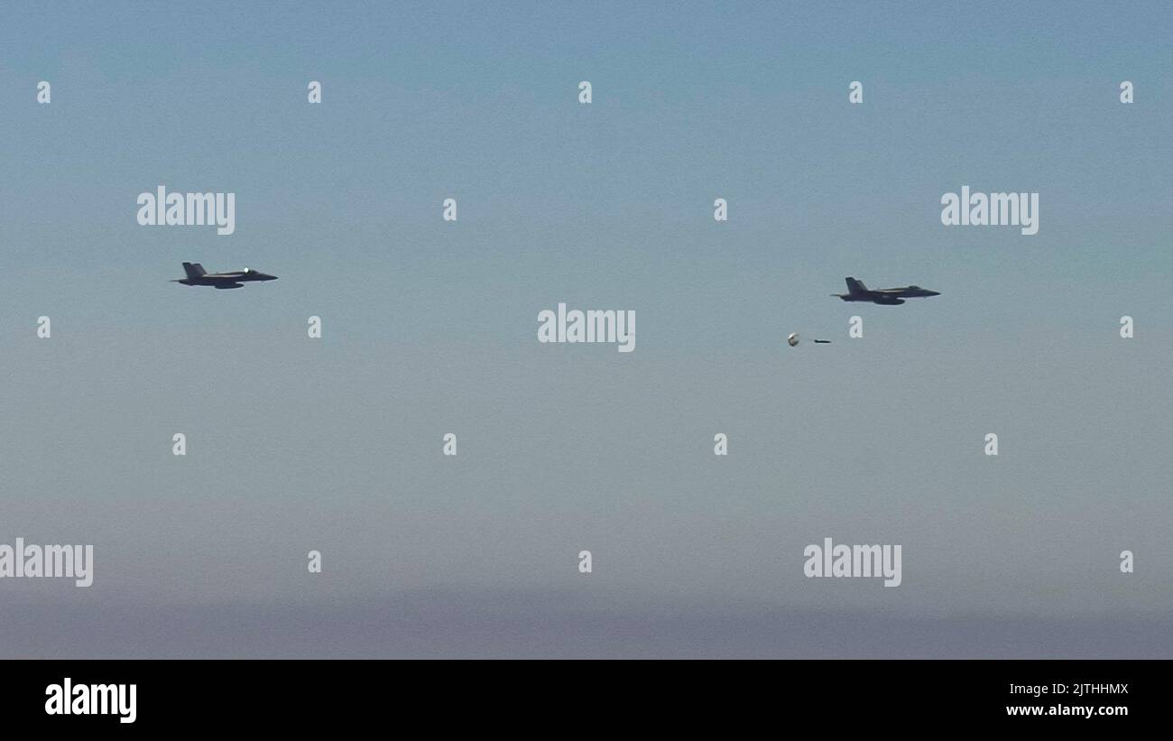 An F/A-18F Super Hornet, right, assigned to Strike Fighter Squadron ...