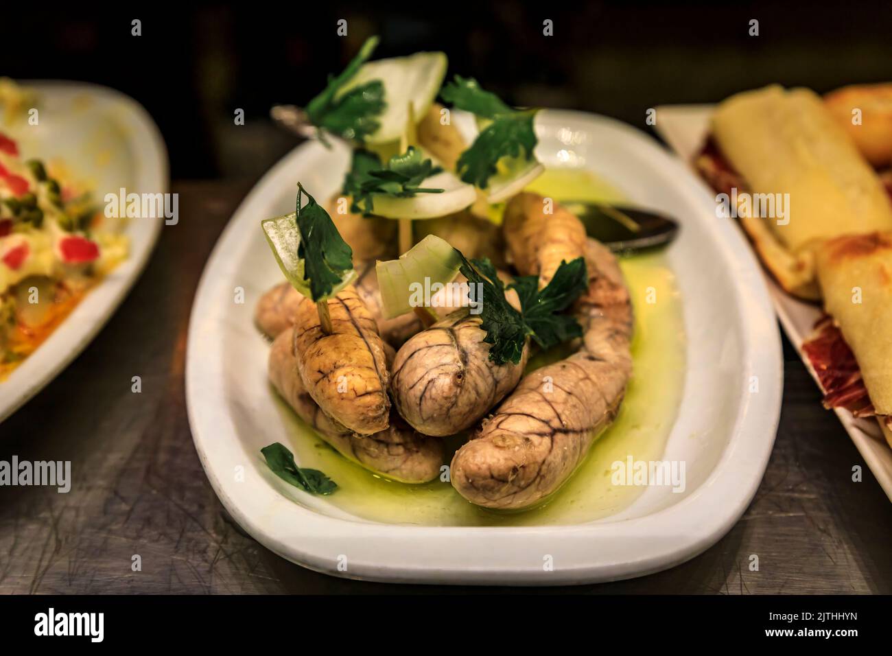 Traditional Basque pintxos sausage in natural casing with raw onion and ...