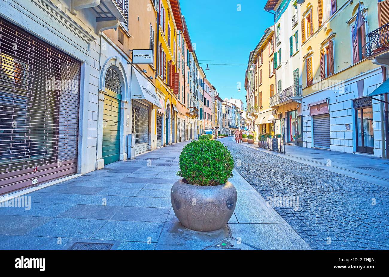 The narrow curved Via della Pace street, lined with colored histroic ...