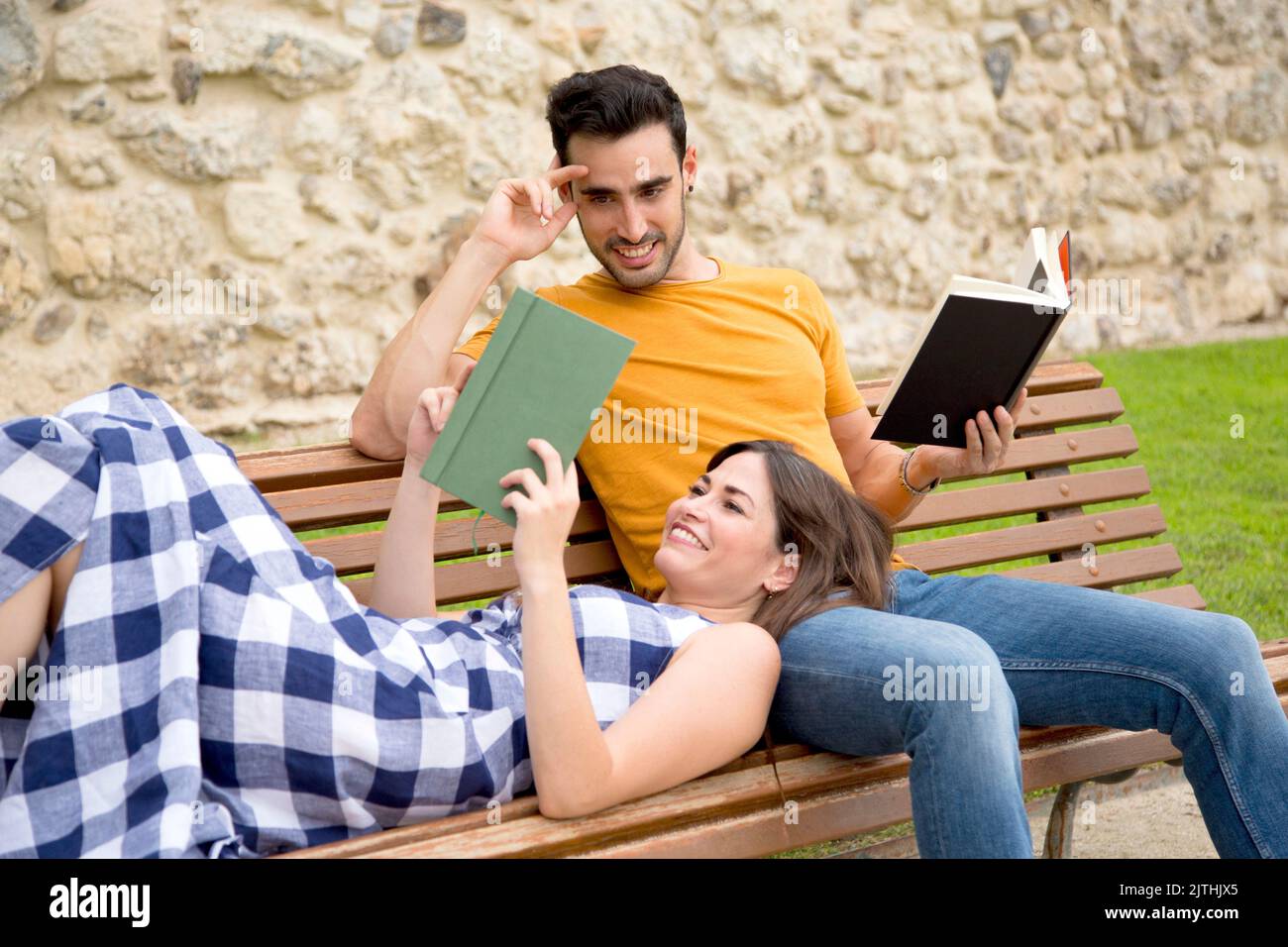 Romantic Scene Of A Smiley Couple Reading Books In A Bench Of A Park
