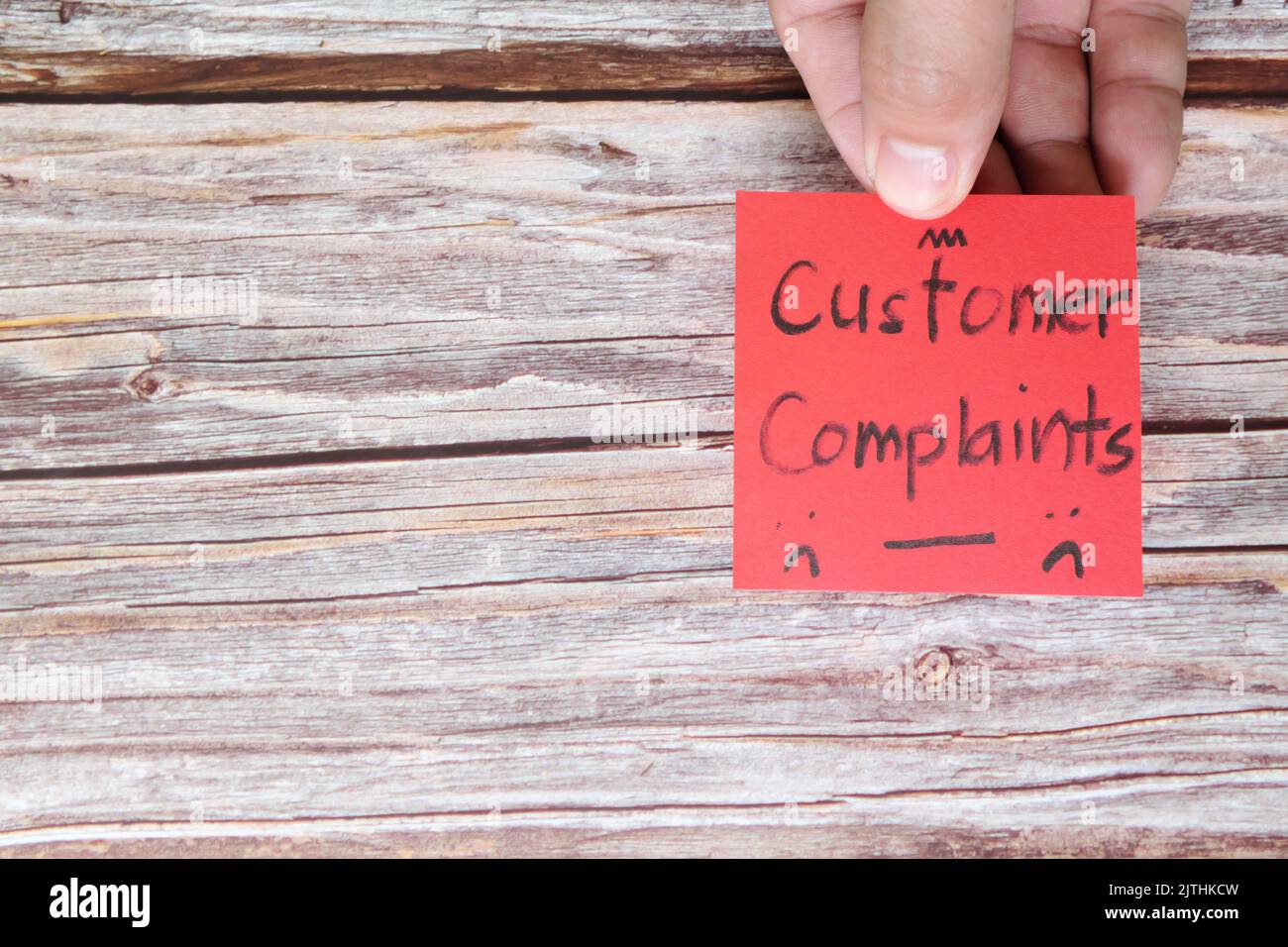 How to handle customer complaint concept. Hand holding red note with ...