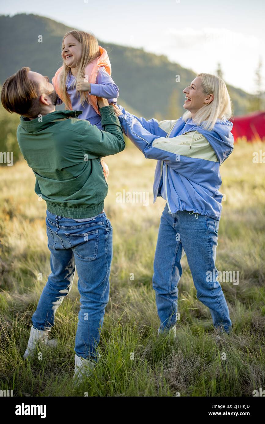 Happy couple with little girl have fun while travel in the mountains ...
