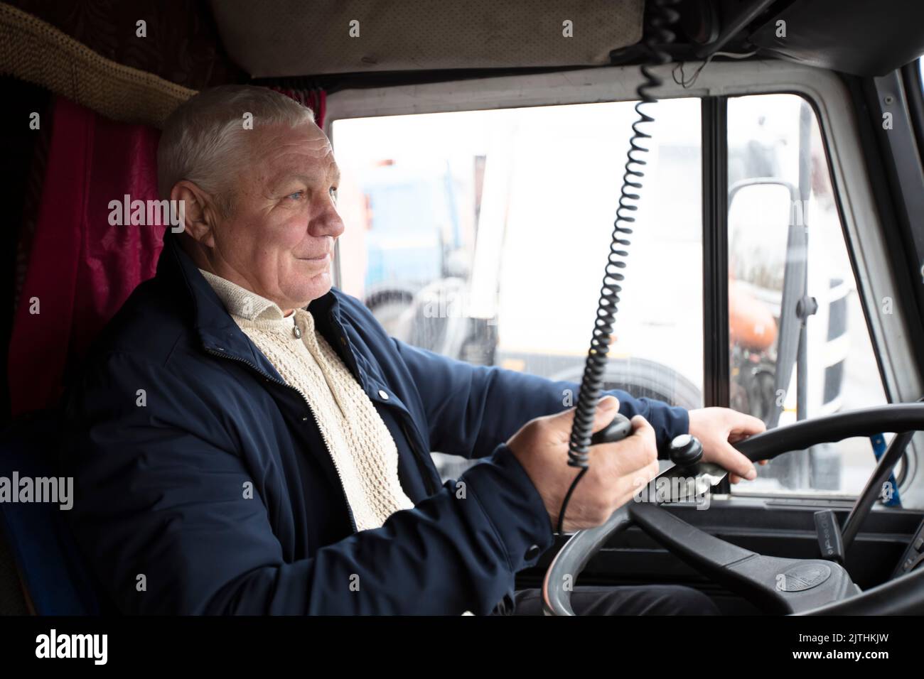 Elderly driver sitting in cabin of big modern truck Stock Photo - Alamy