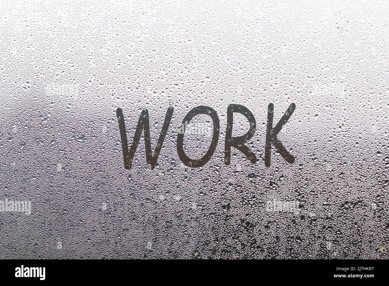 the word work written on night wet window glass close-up with blurred ...