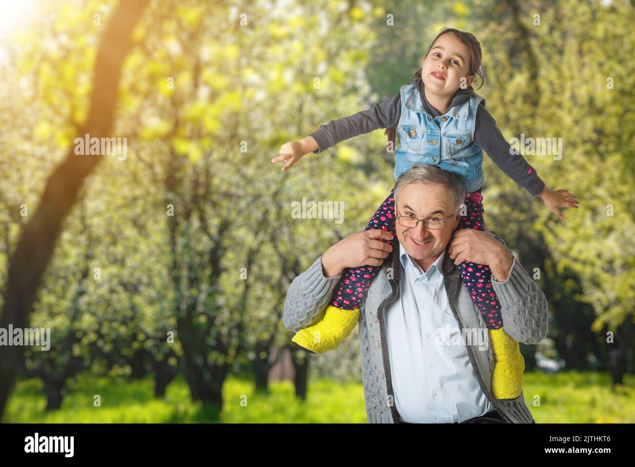 Authentic photo of smiling grandfather hugging with his granddaughter ...