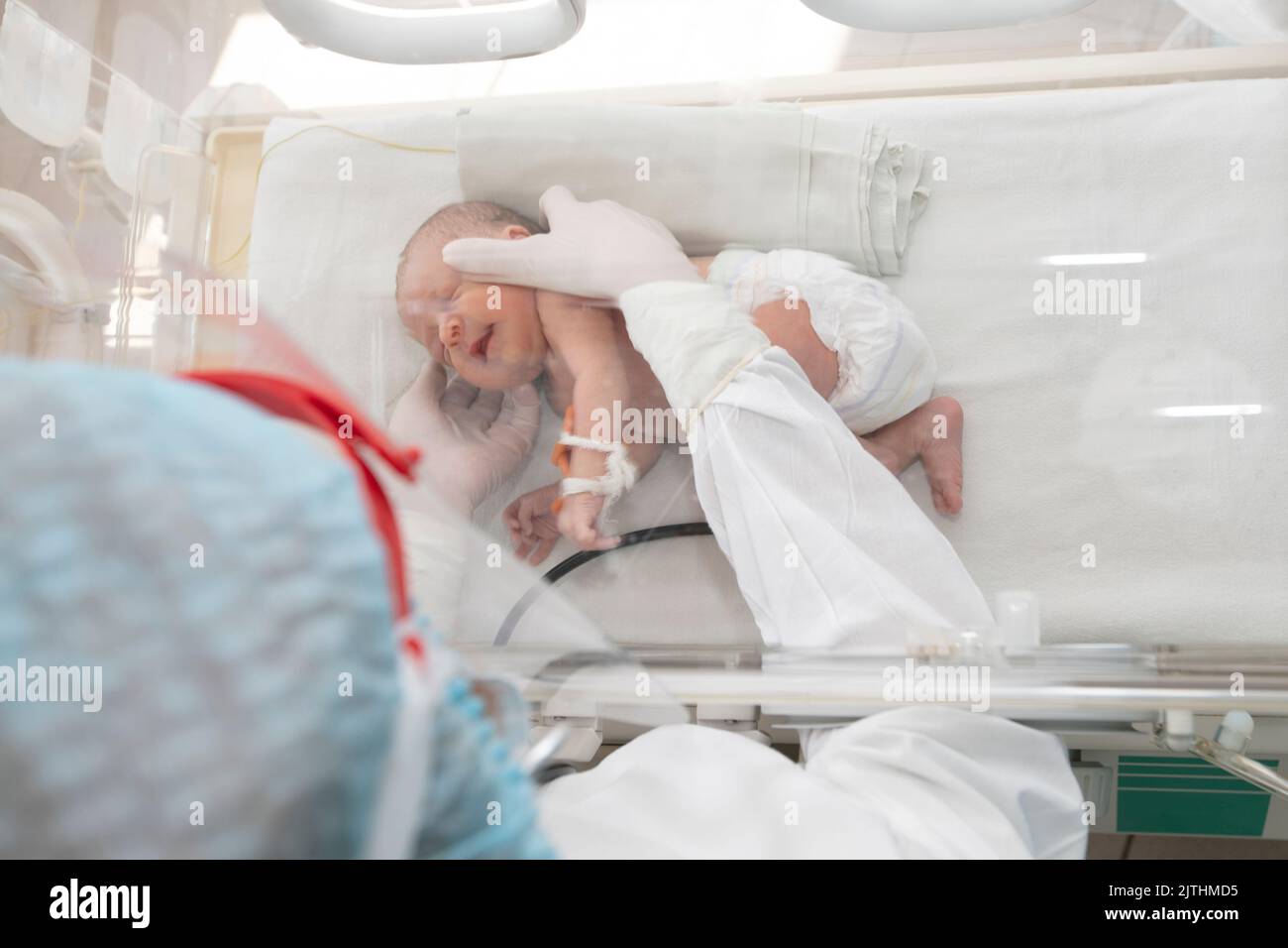 A newborn baby lies in boxes in the hospital. A child in an incubator ...