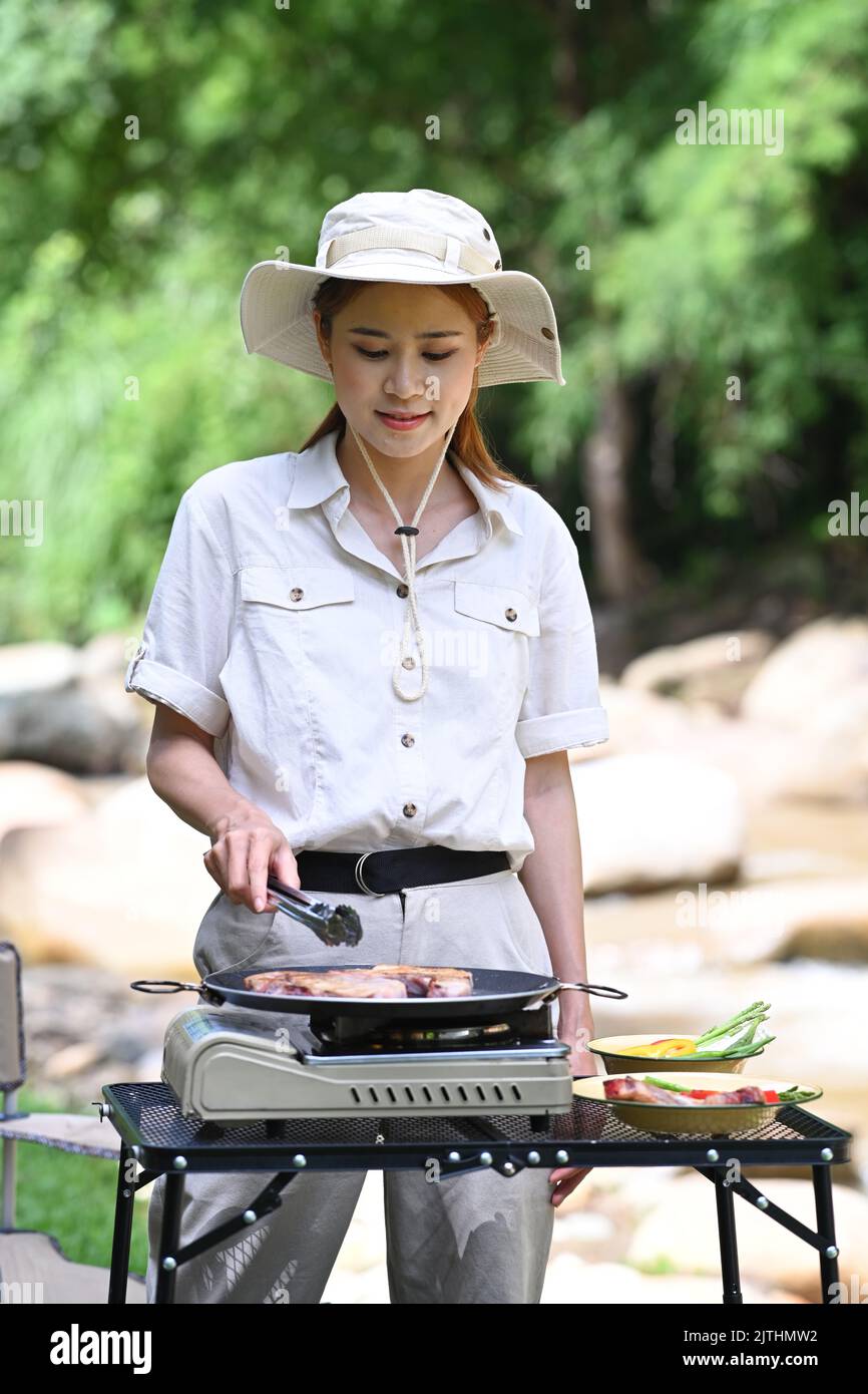 Happy young asian female traveler camping in nature park on beautiful ...