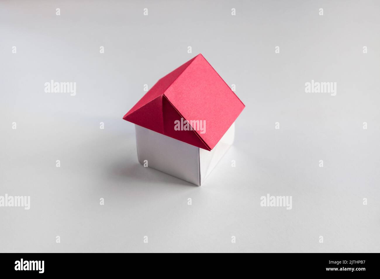 White and red paper house origami isolated on a blank background Stock ...
