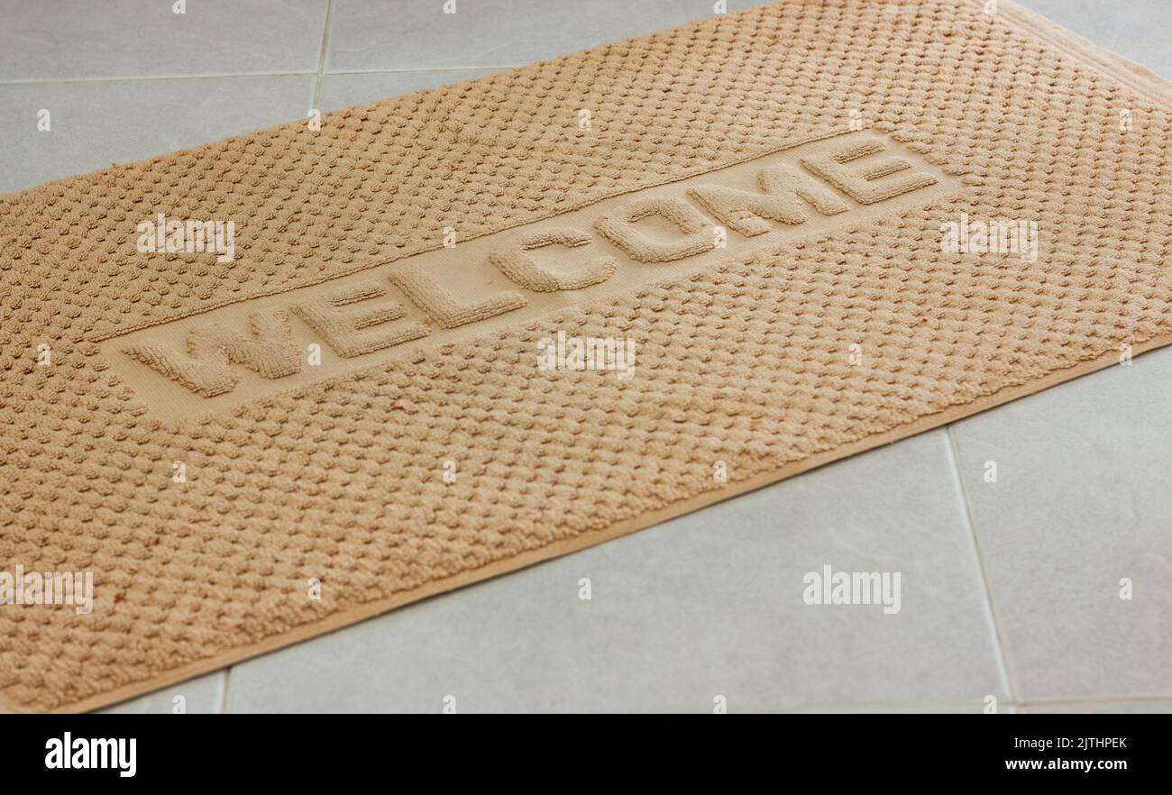 Bath towel with welcome sign on the bathroom floor. Hotel resort guest ...